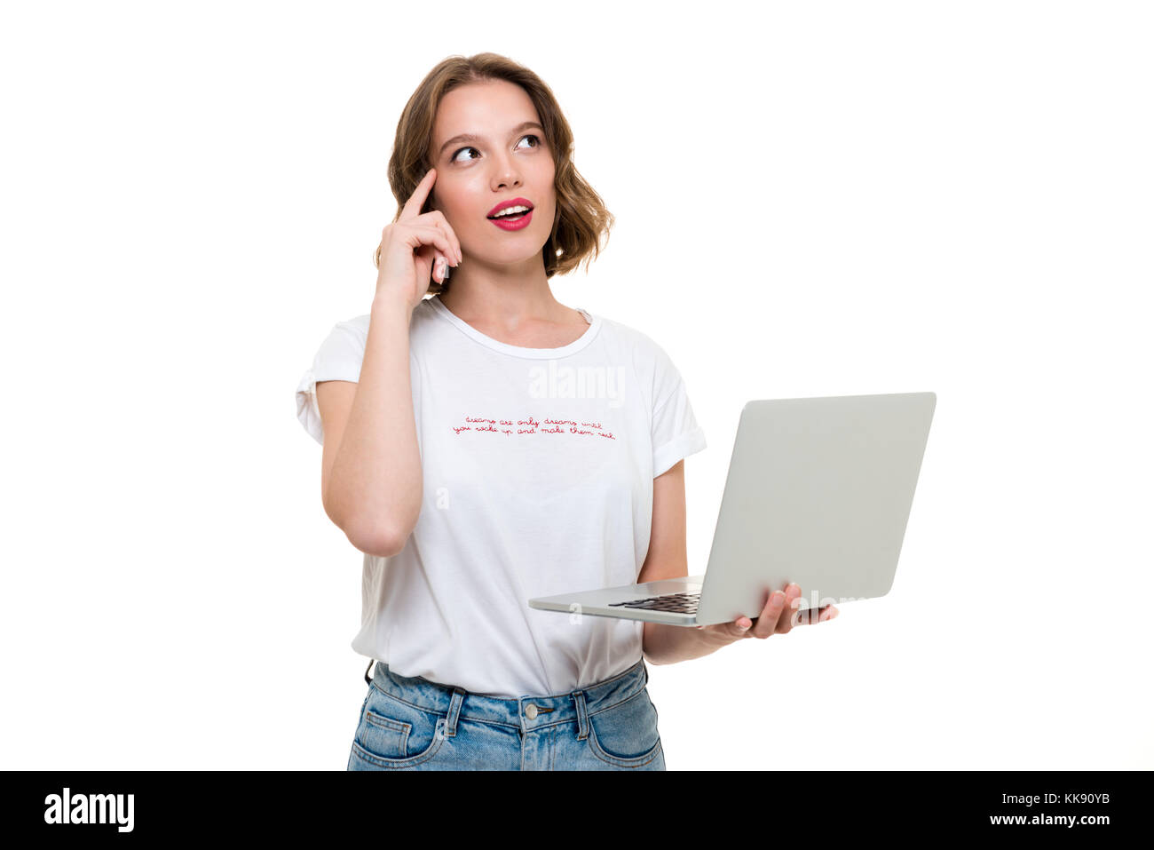 Portrait of a thoughtful woman holding laptop computer while standing ...