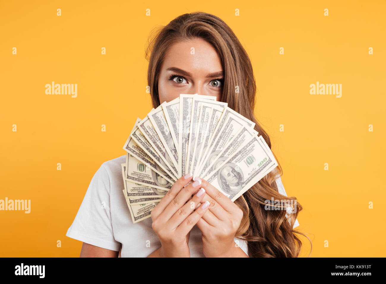 Close up portrait of a young girl covering her face with money ...