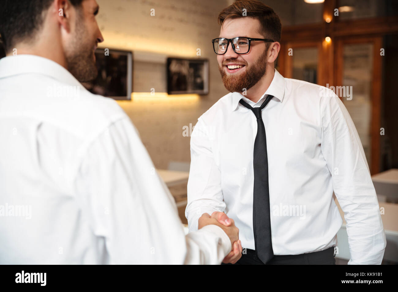 Portrait of two smiling businessmen shaking hands to make a deal ...