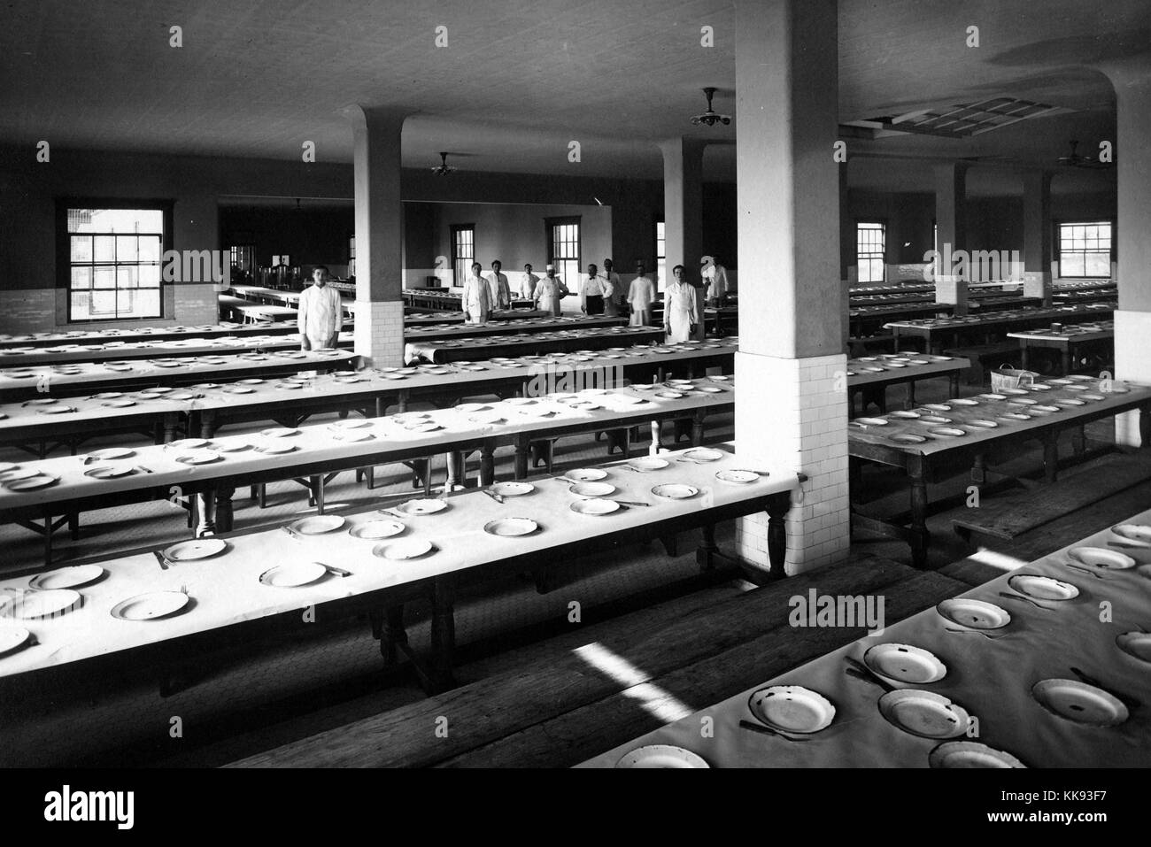 Black and white photograph of a large dinning hall, empty except for a ...