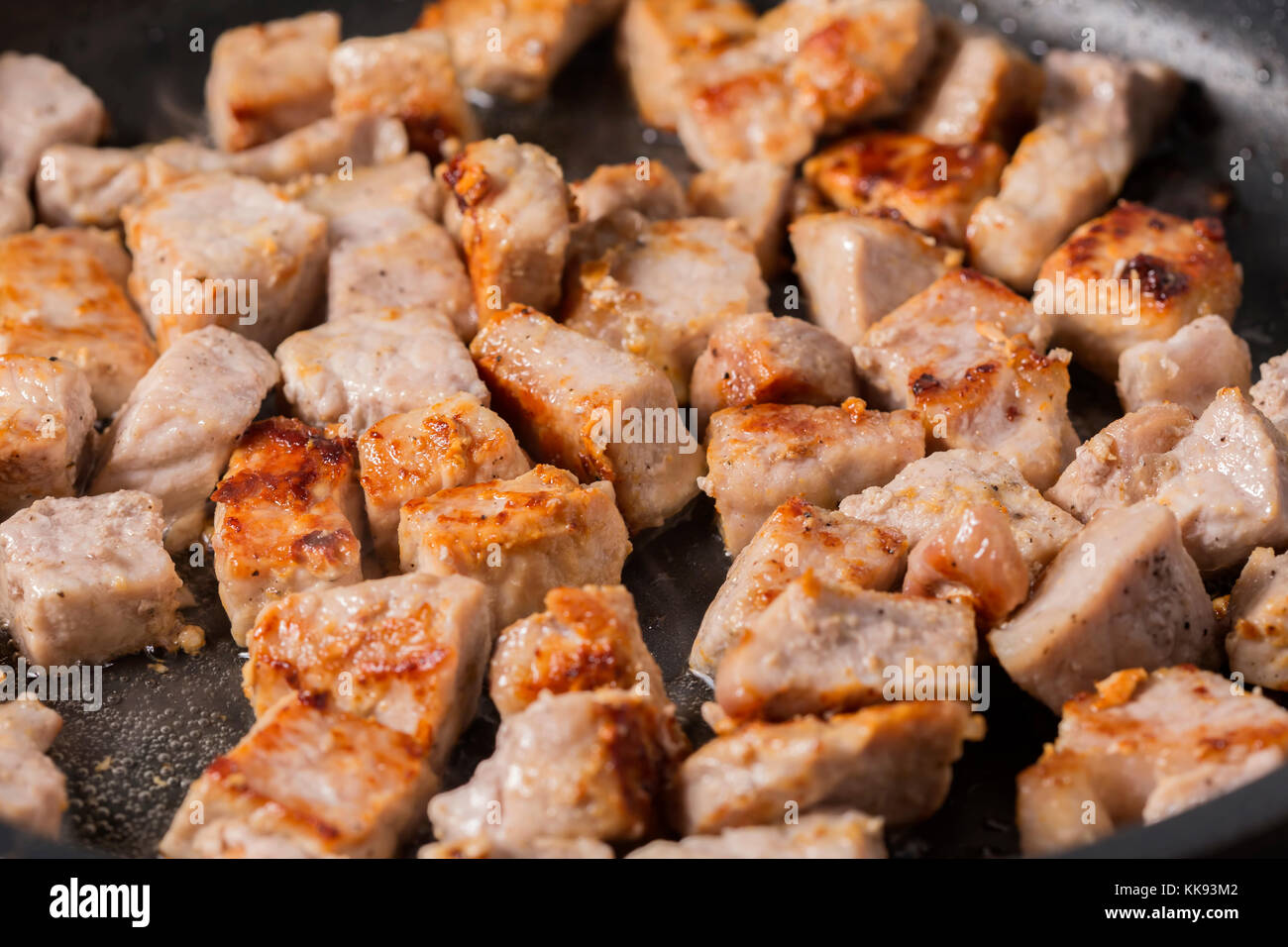 Close up of fried small pork pieces in pan Stock Photo - Alamy