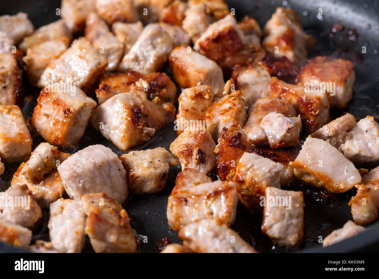 Close up of fried small pork pieces in pan Stock Photo - Alamy