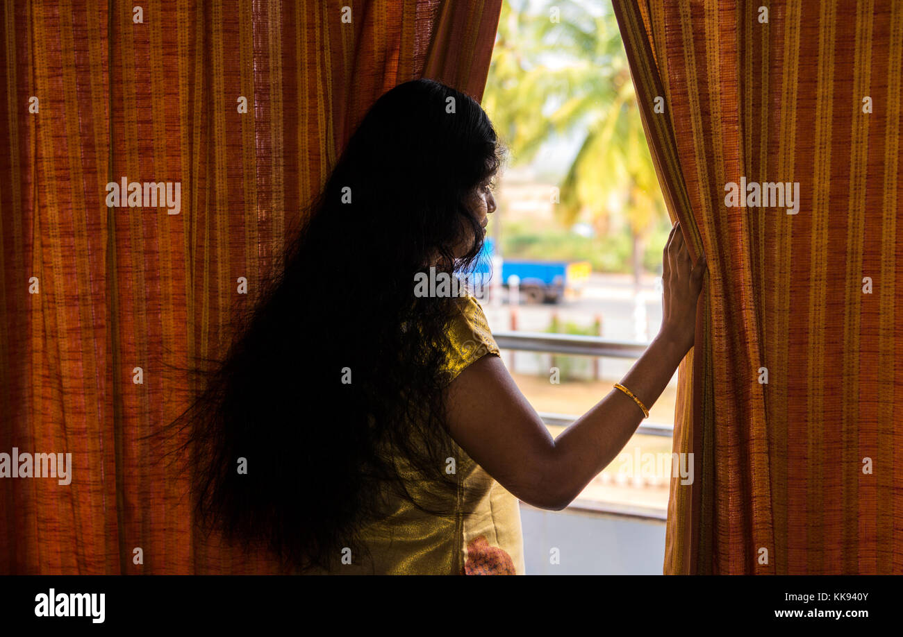 Girl watching outside through the window Stock Photo - Alamy