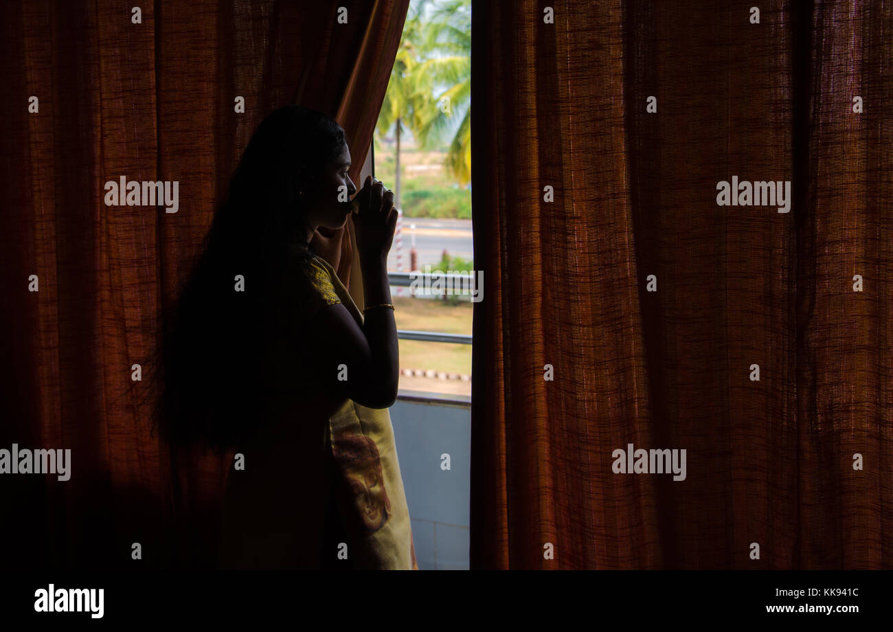 Girl having her morning coffee watching outside thru window Stock Photo ...