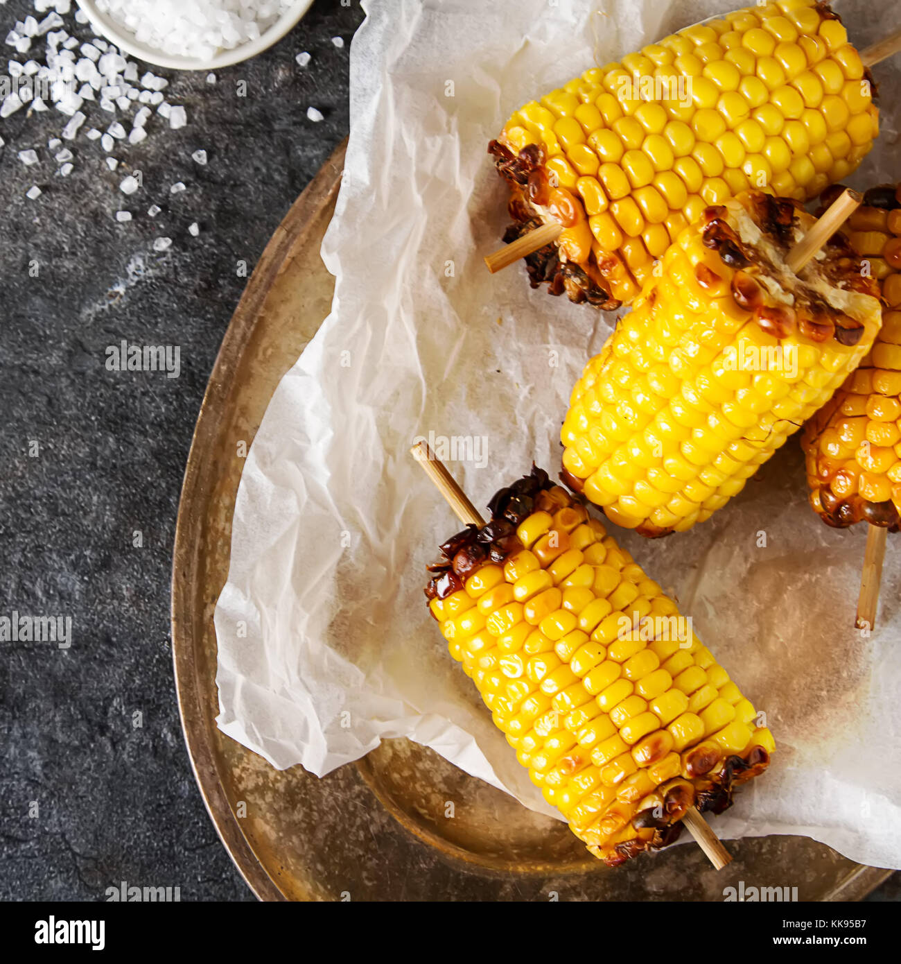Corn grilled with salt and spices. Dark background. Fast food in the ...