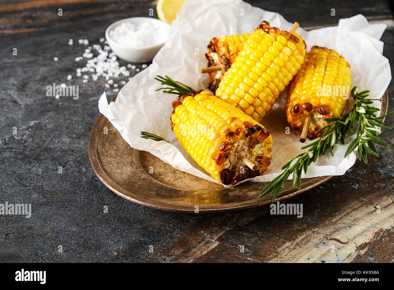 Corn grilled with salt and spices. Dark background. Fast food in the ...