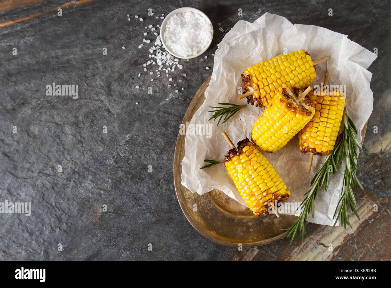 Corn grilled with salt and spices. Dark background. Fast food in the ...