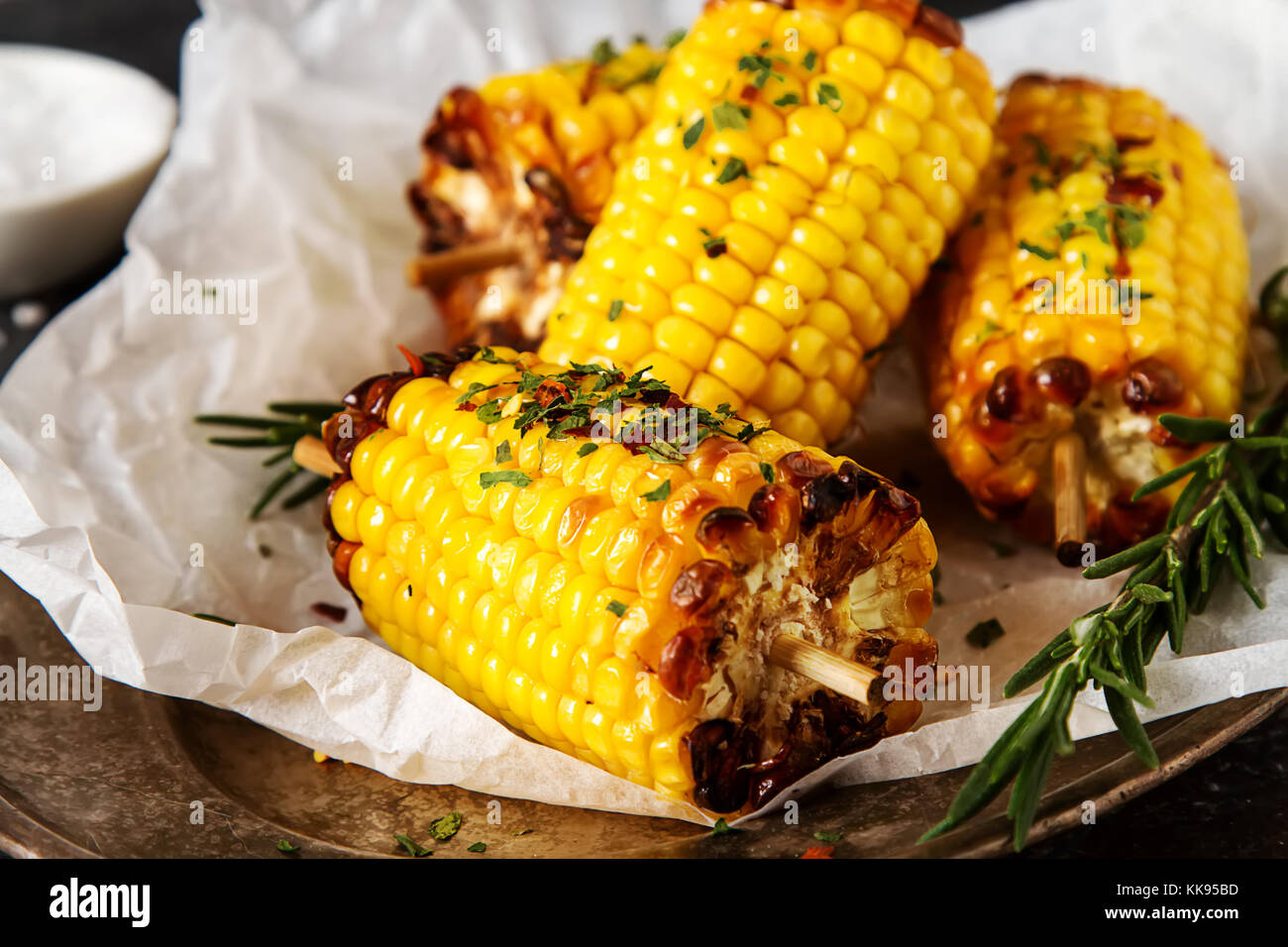 Corn grilled with salt and spices. Dark background. Fast food in the ...