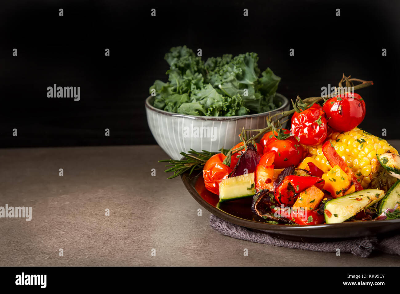 Grilled vegetables with salt and spices. Dark background. Fast food in ...