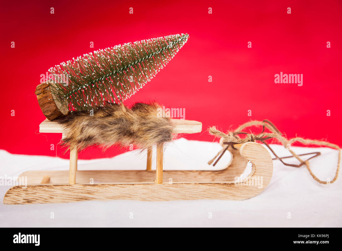 Christmas tree on a sled, snow and red background, side view Stock ...