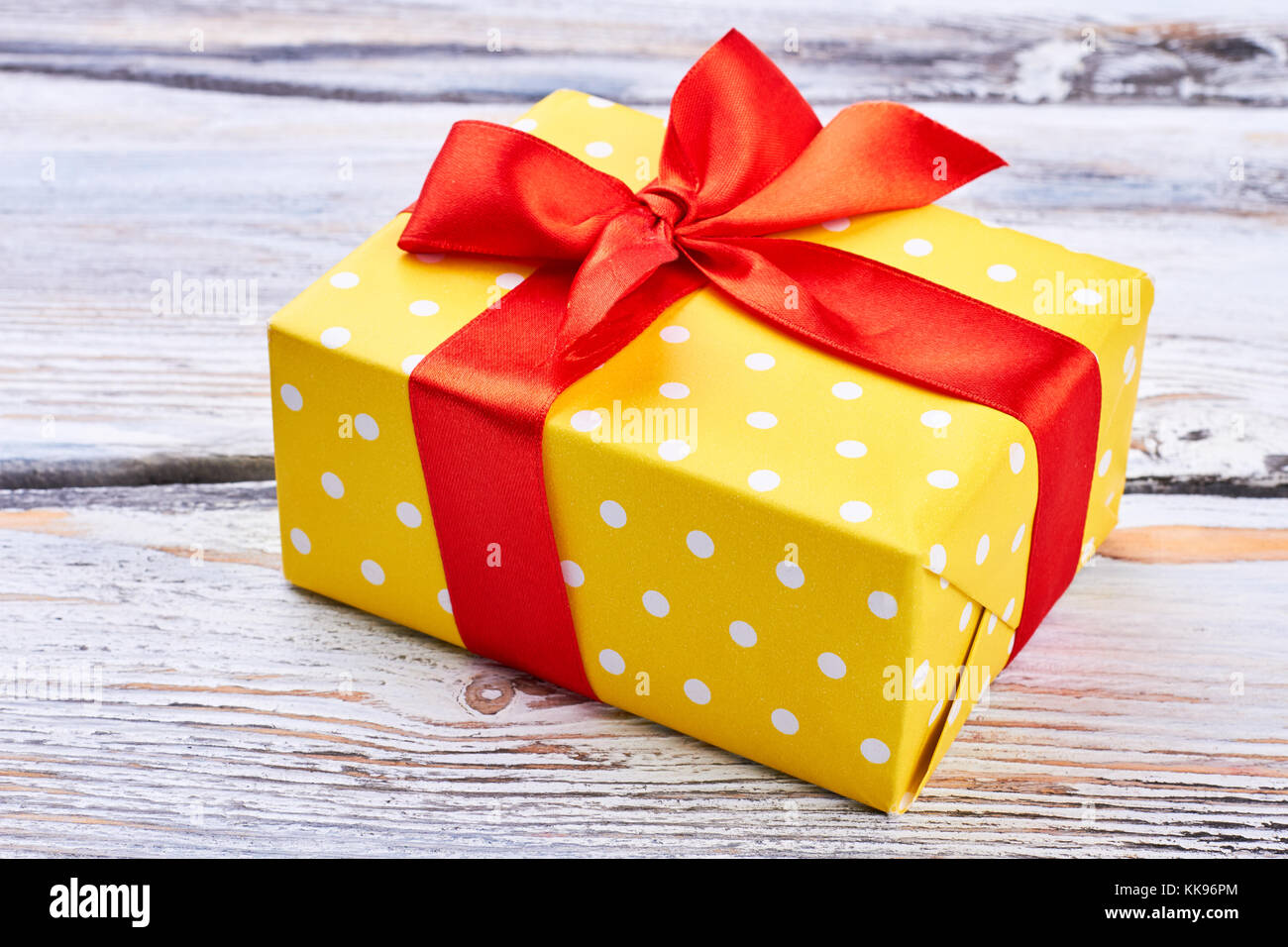 Yellow gift box with red ribbon Stock Photo - Alamy