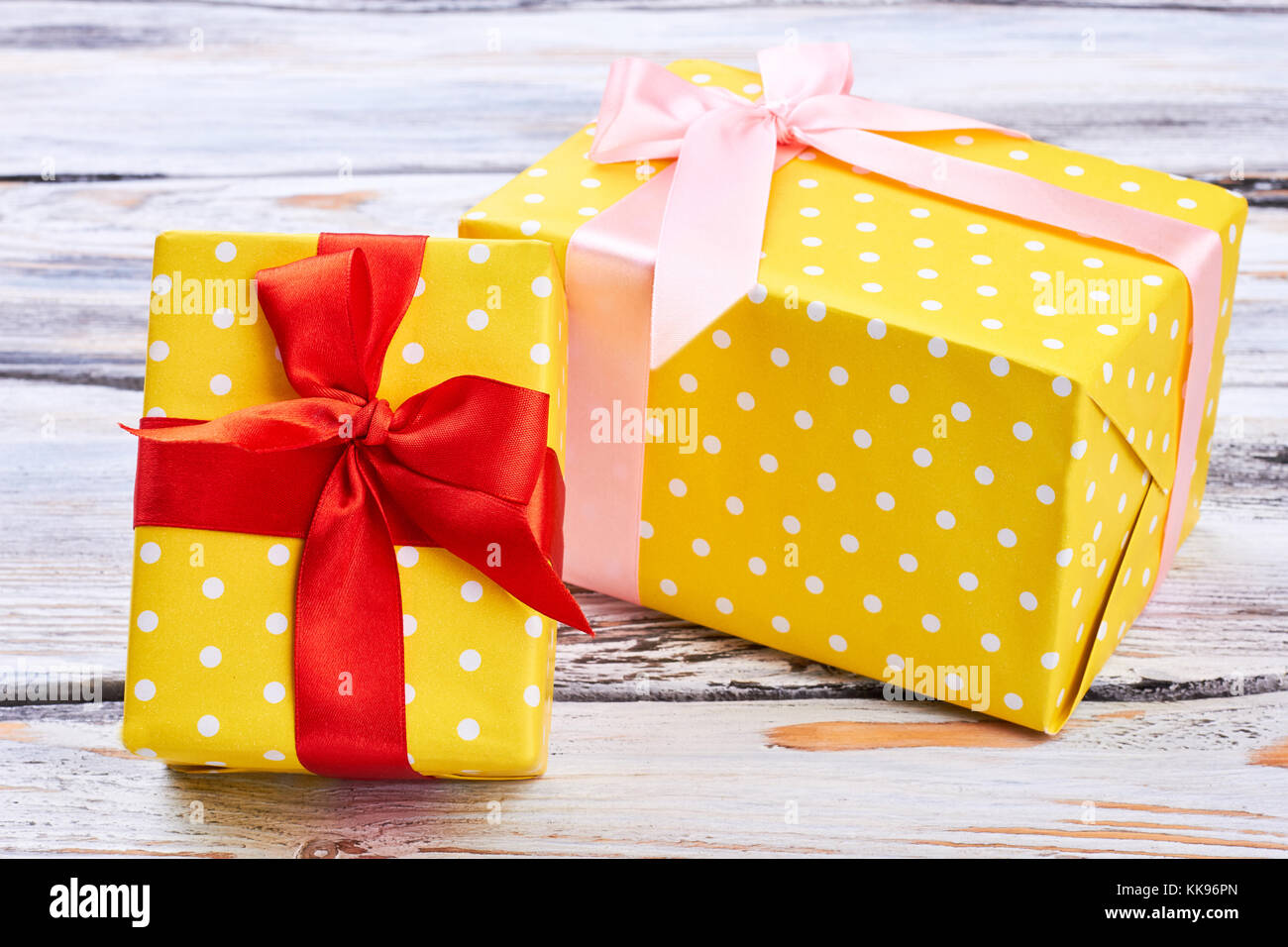 Two yellow gift boxes, wooden background Stock Photo - Alamy