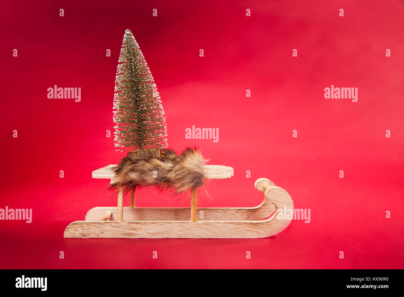Christmas tree on a sled, red background Stock Photo - Alamy