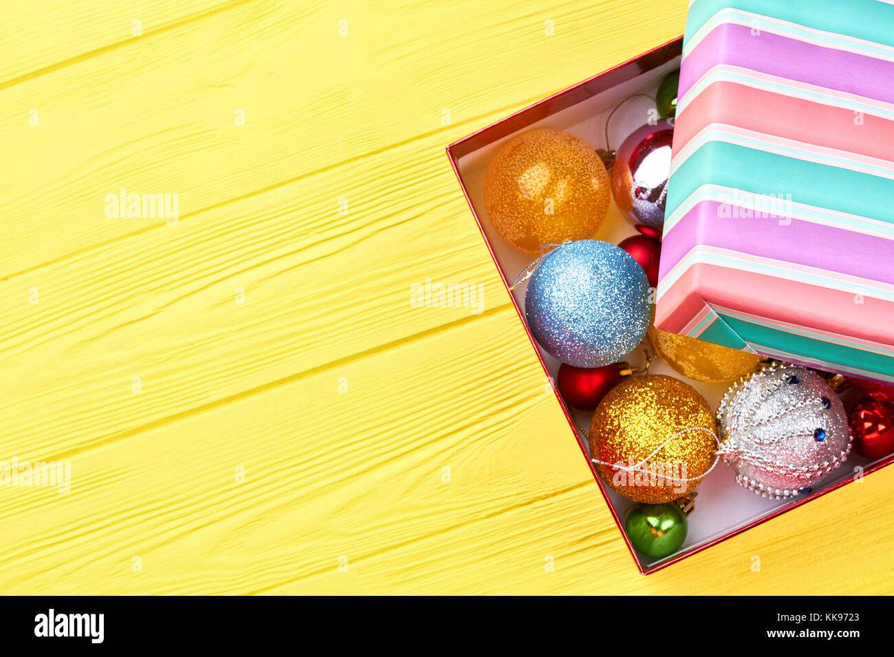 Striped box with shiny Christmas decorations Stock Photo - Alamy