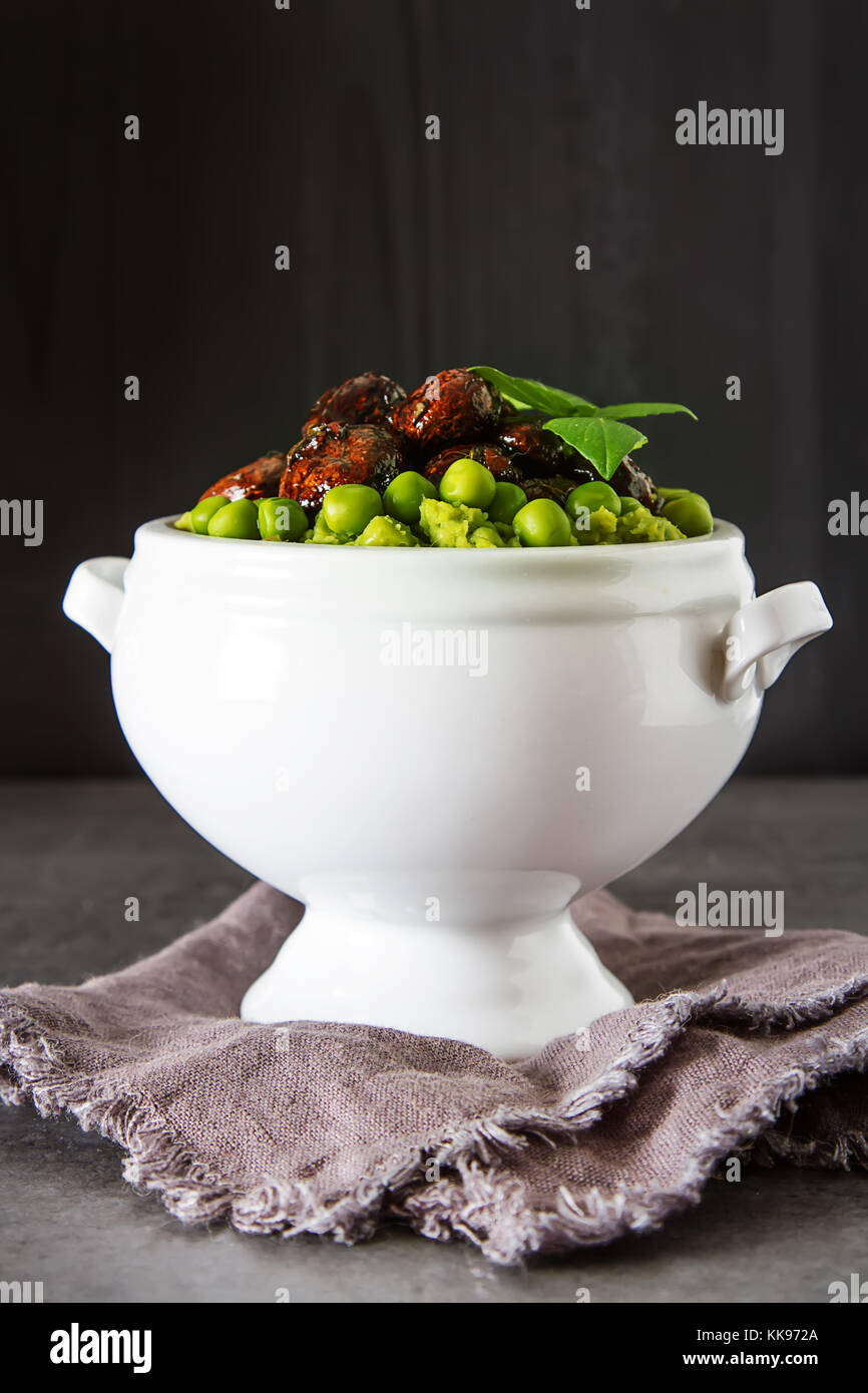Pea puree with mushrooms in a white ceramic bowl. Delicious vegetarian ...