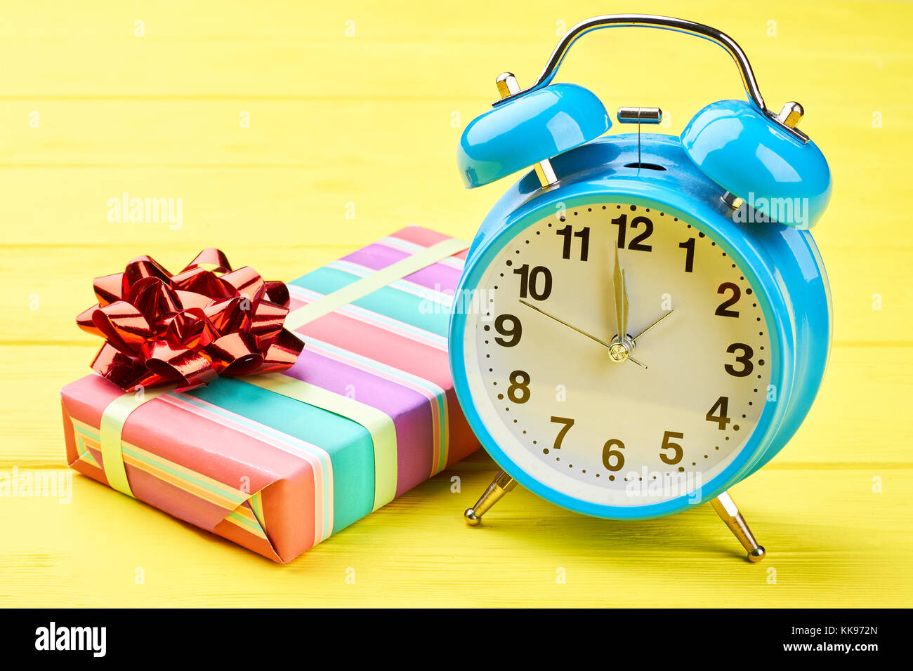 Gift box with bow and alarm clock Stock Photo - Alamy