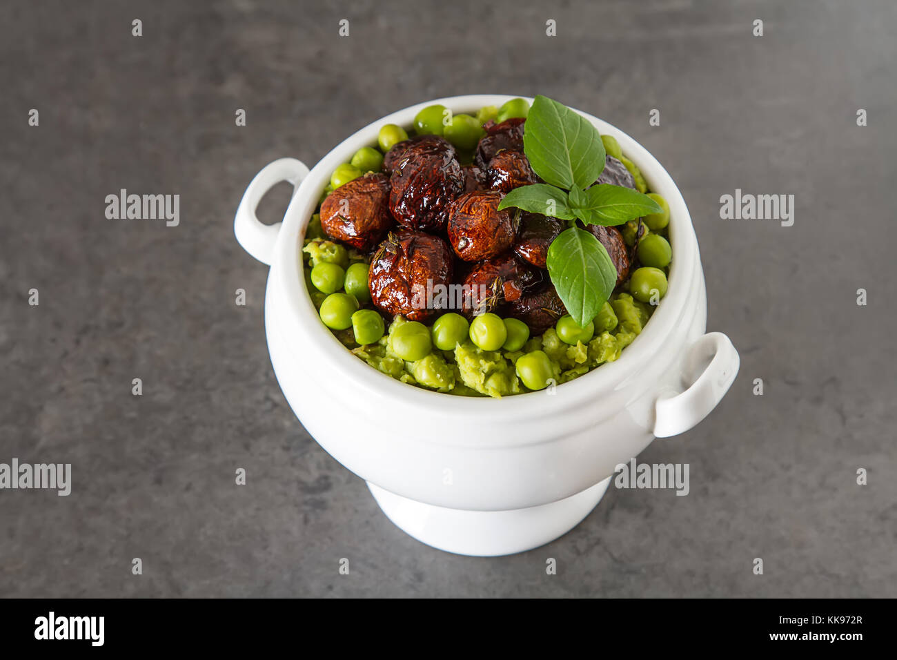Pea puree with mushrooms in a white ceramic bowl. Delicious vegetarian ...