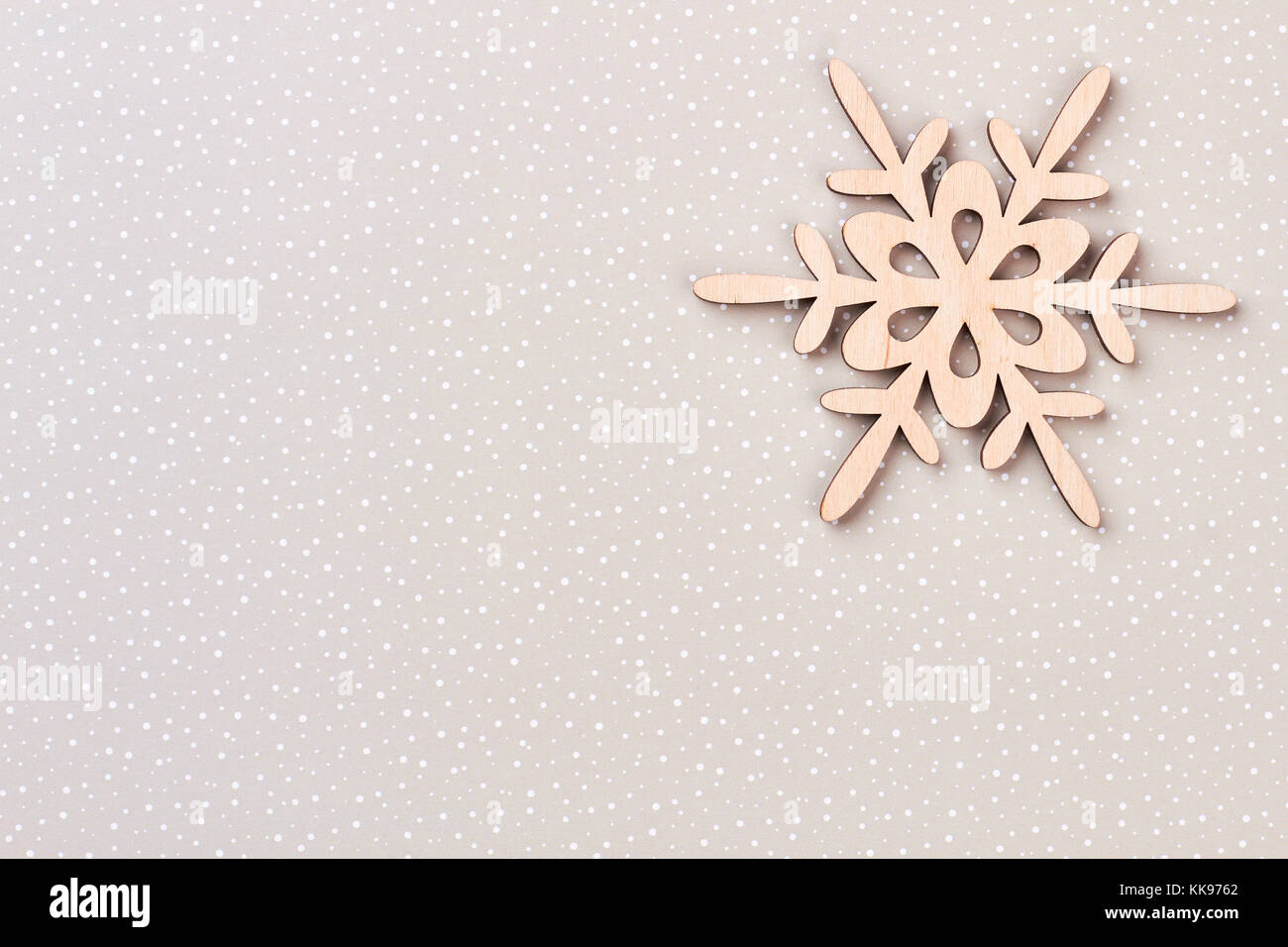 Wooden snowflake on winter paper background Stock Photo - Alamy