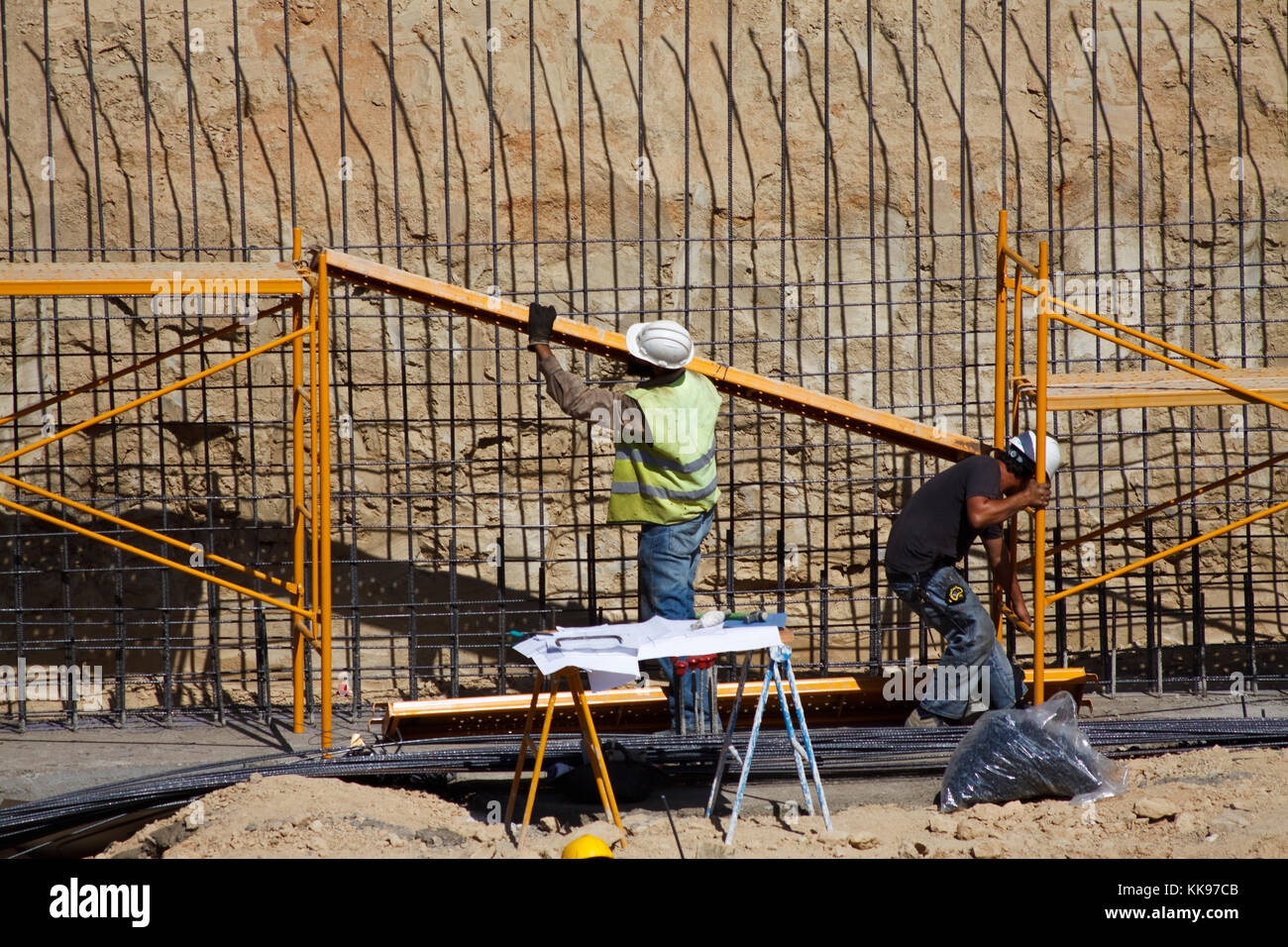 Two workers in a building construction under a bright sun Stock Photo ...