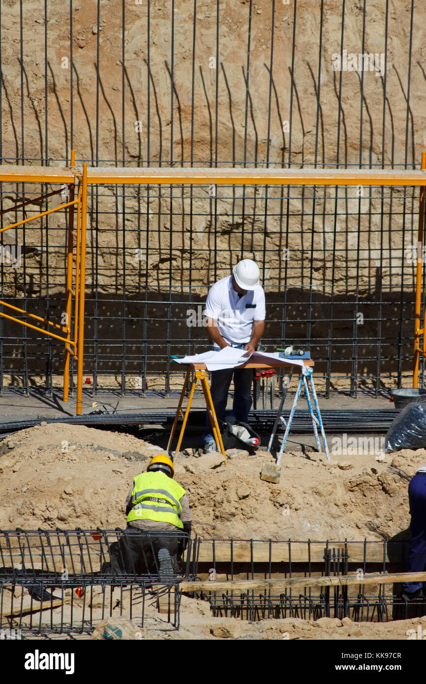 A worker reading construction plans white other is working Stock Photo ...