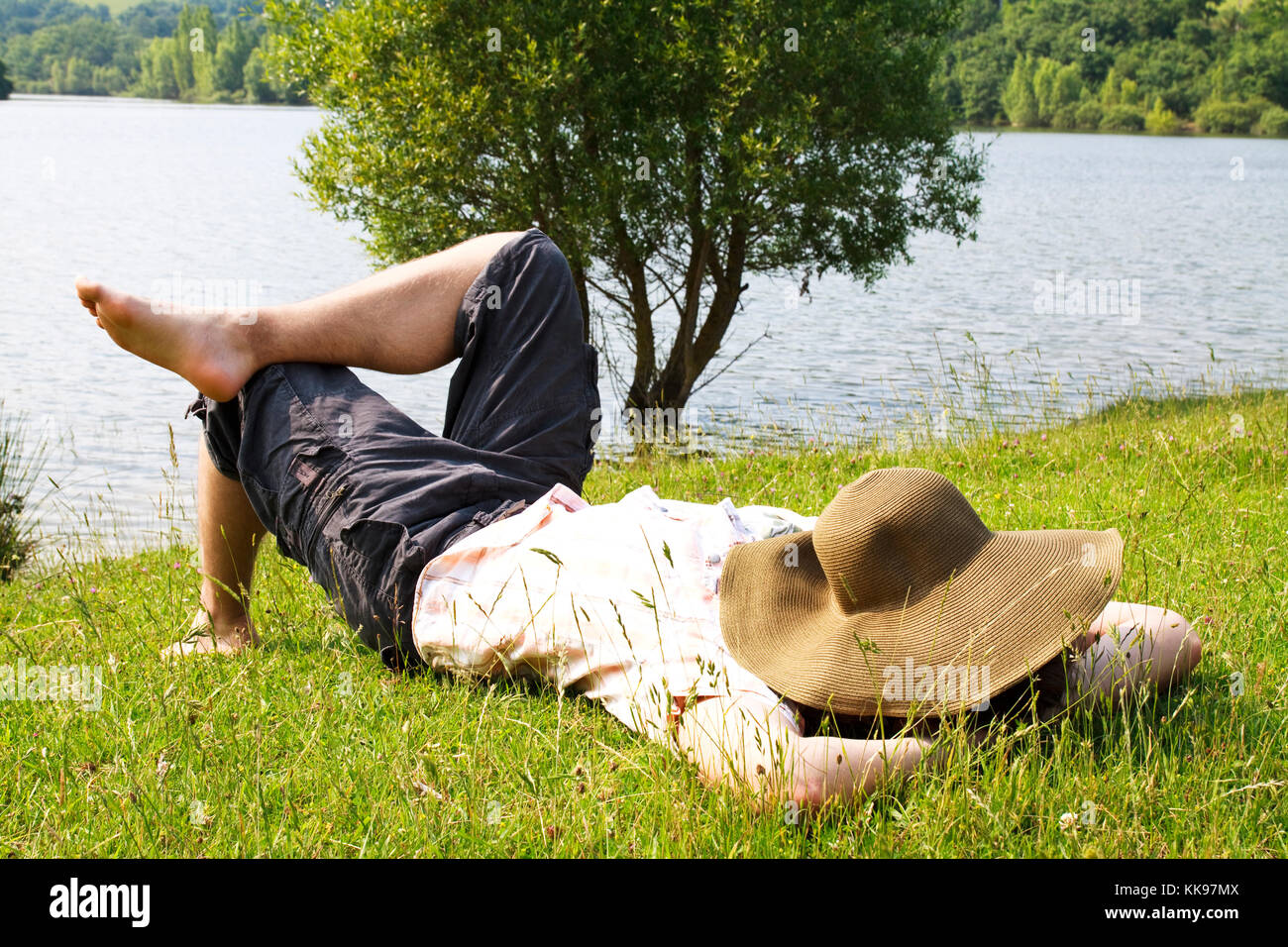 A man taking a nap after meal with a straw hat on face Stock Photo - Alamy