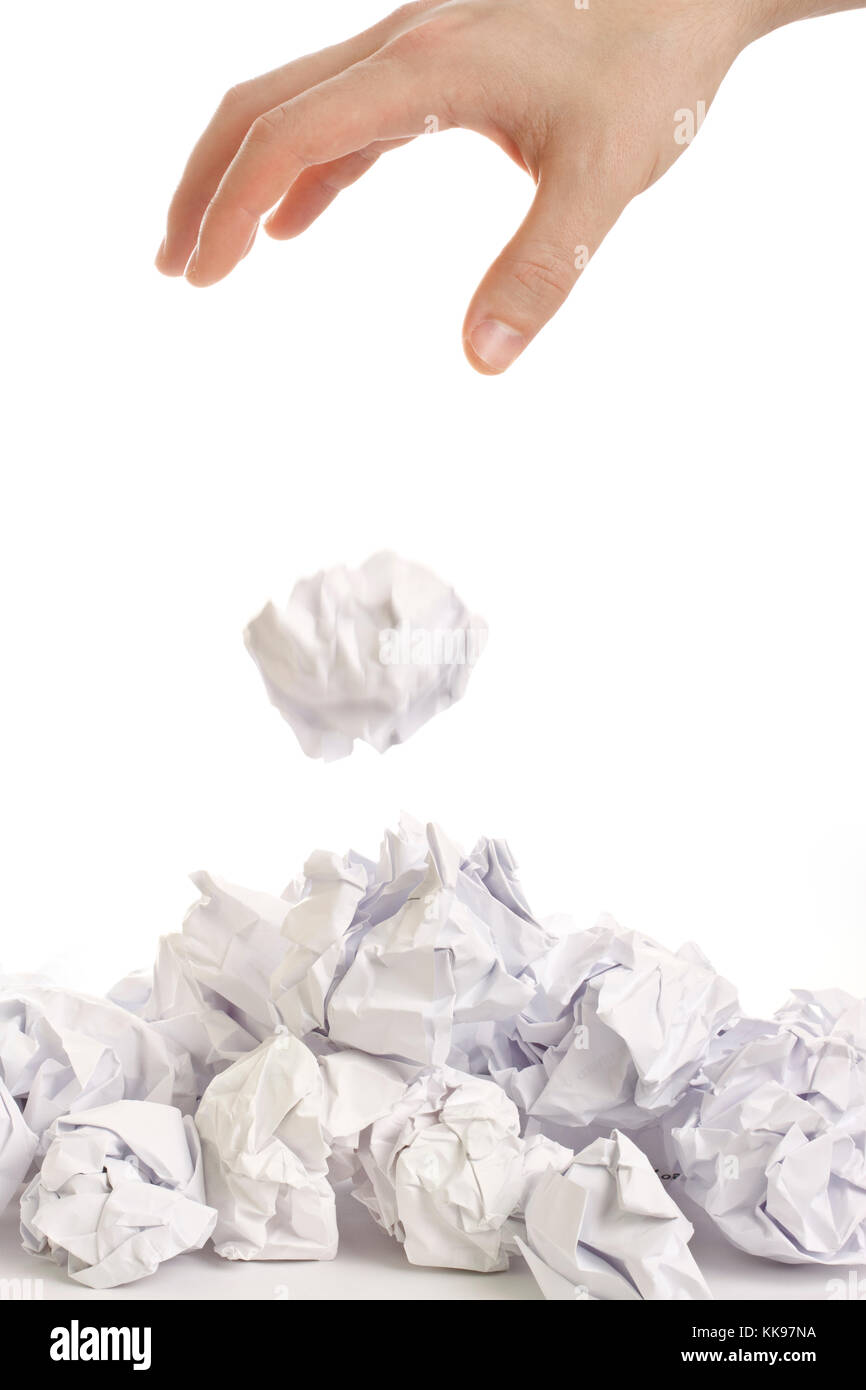 Male hand throwing trash on a paper pile, isolated on white background ...