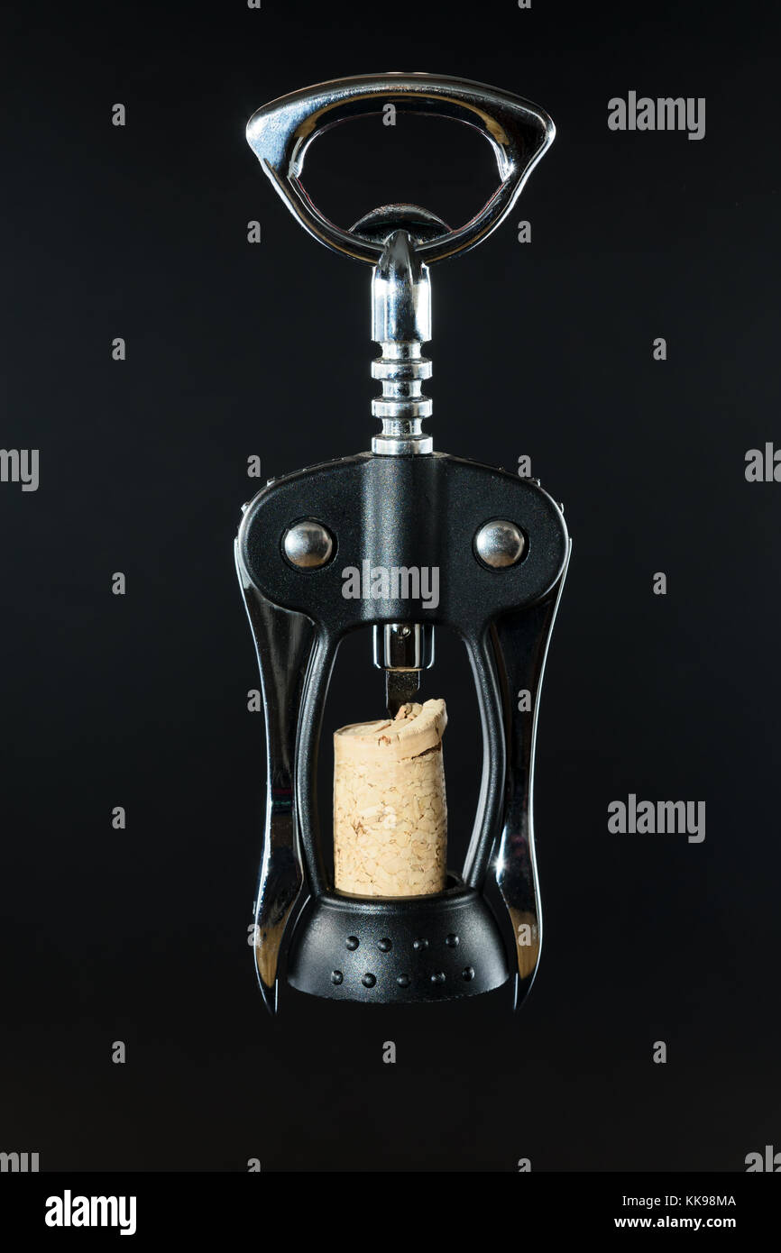 Corkscrew with extracted cork dark background Stock Photo - Alamy