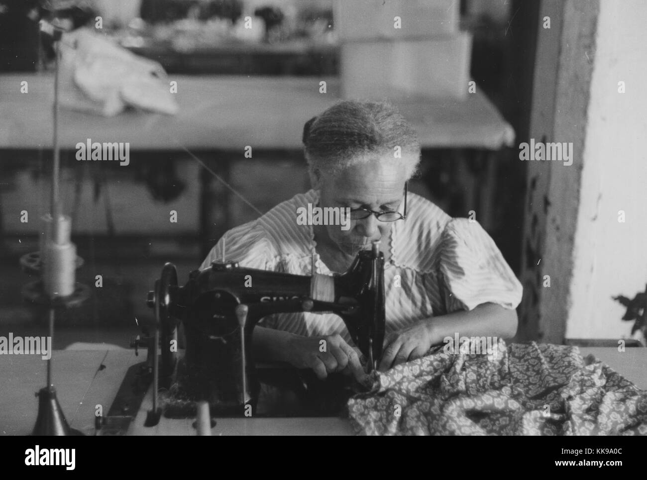 A photograph of a mature Puerto Rican woman using a sewing machine in ...