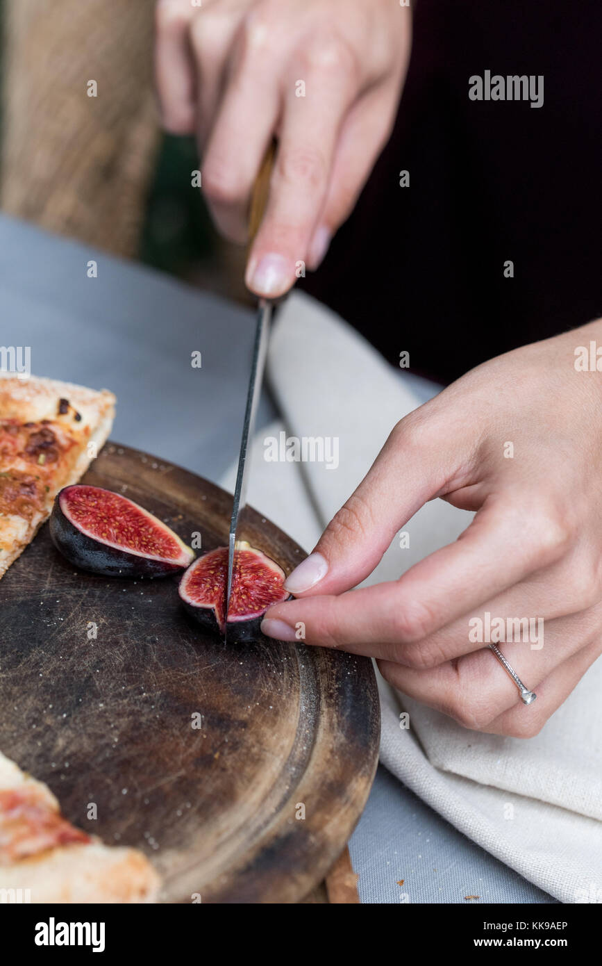 Close up female hands cutting fig with knife Stock Photo - Alamy