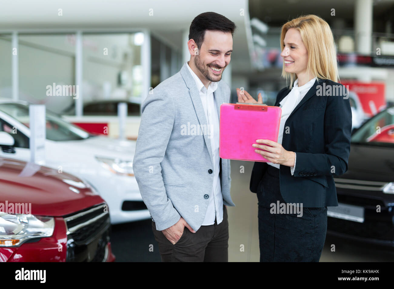 Professional salesperson selling cars at dealership to buyer Stock ...