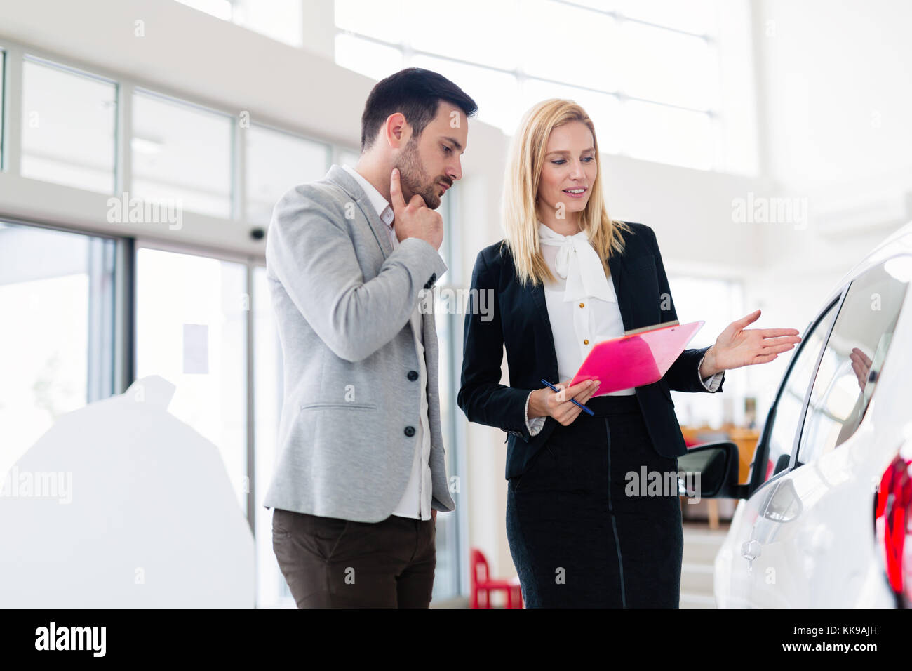 Professional salesperson selling cars at dealership to buyer Stock ...