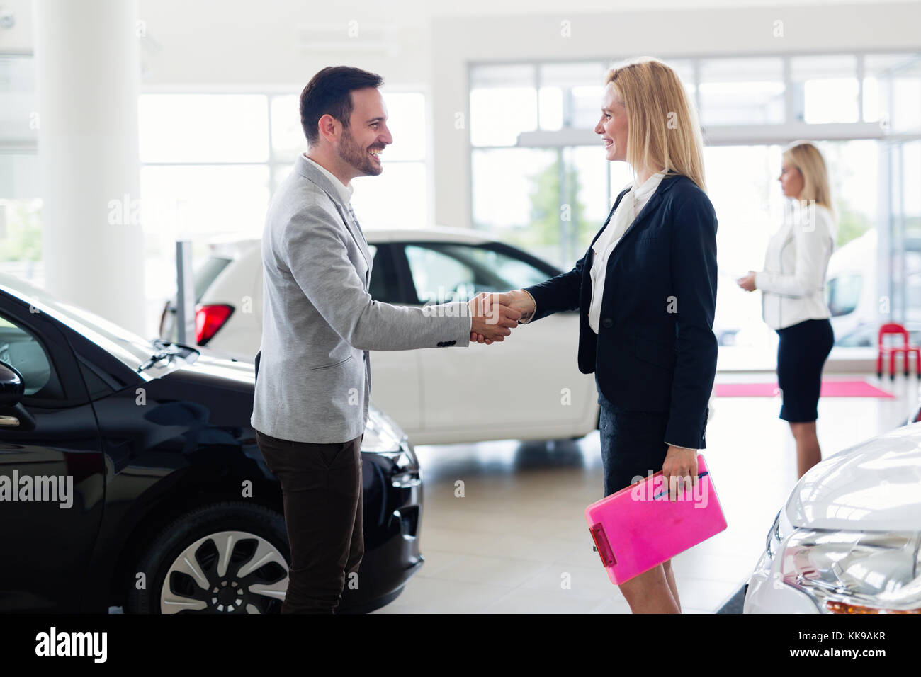 Professional salesperson selling cars at dealership to buyer Stock ...