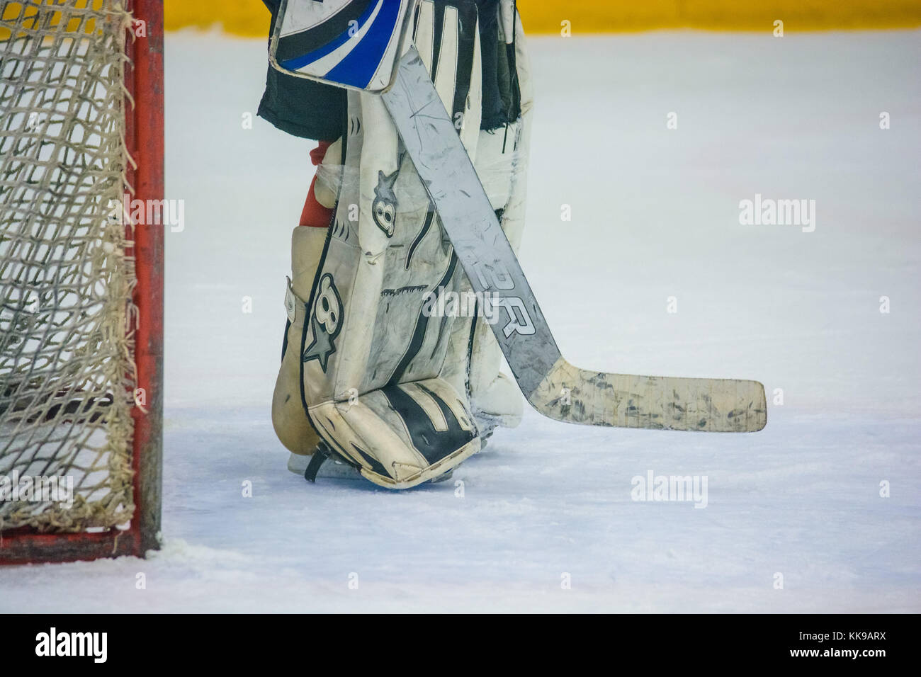 Closeup image of hockey goalkeeper's legs and feet in red and black ...