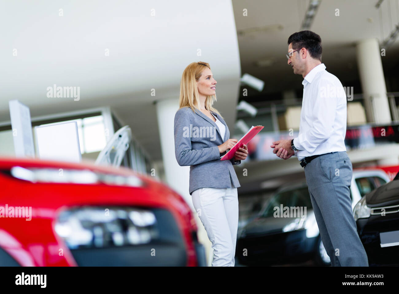 Professional salesperson selling cars at dealership to buyer Stock ...