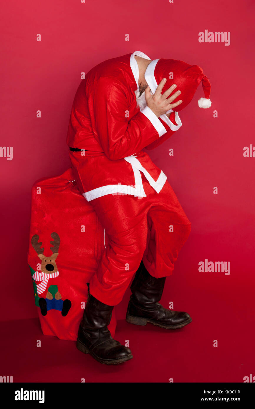Broken Santa Claus sitting on a bag stuffed with presents Stock Photo ...