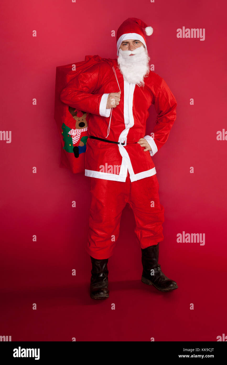 Cool Santa Claus stands with a bag full of gifts Stock Photo - Alamy