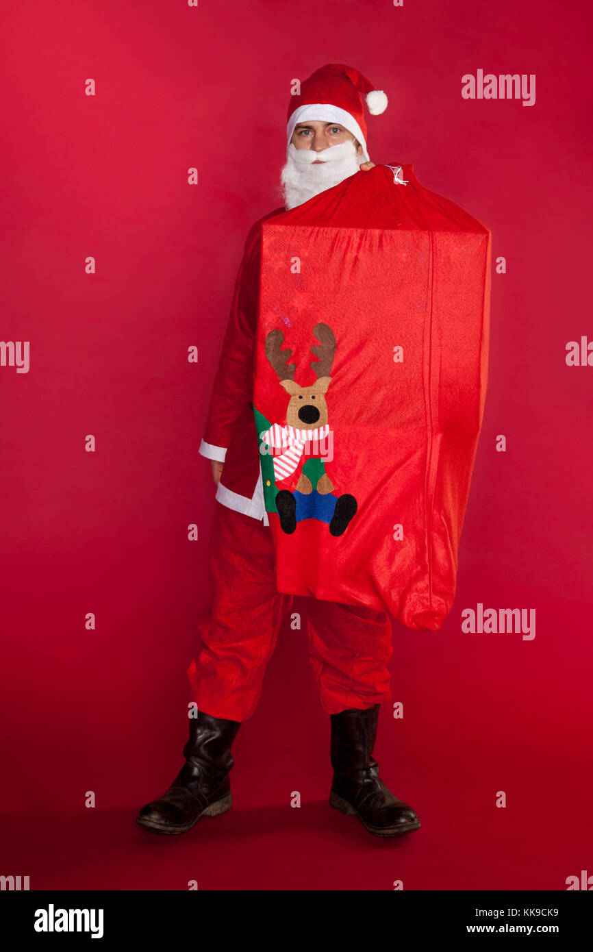 Santa Claus holds a heavy bag on his back Stock Photo - Alamy