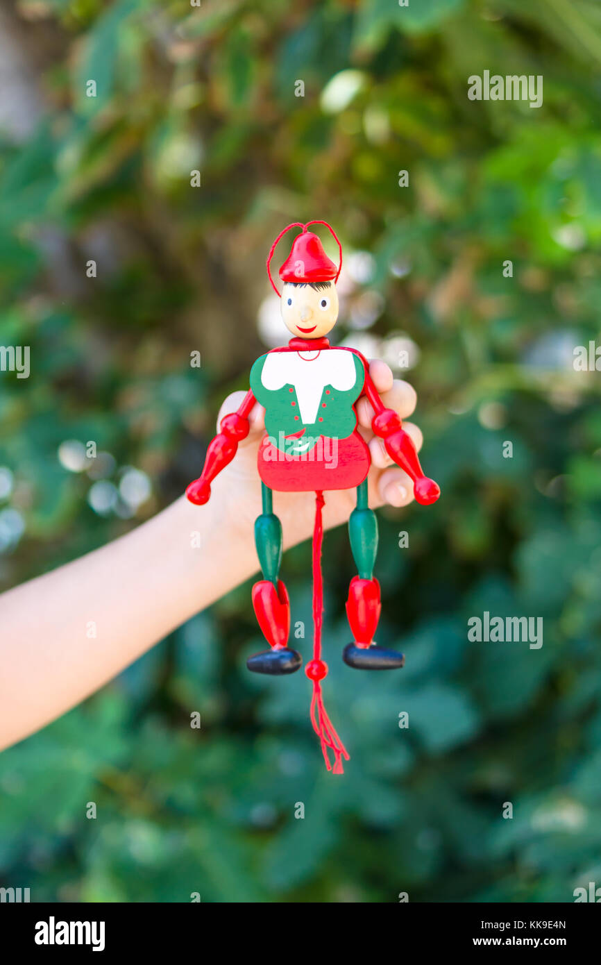 A wooden toy of Pinocchio in children's hands Stock Photo - Alamy