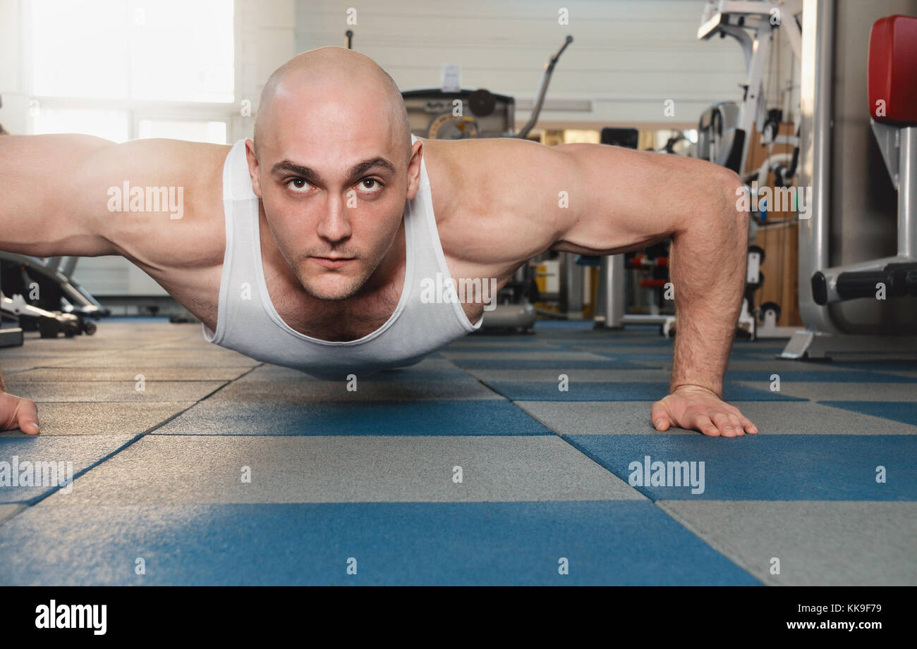 Muscle man making push ups in the gym. Fitness, training and lifestyle ...