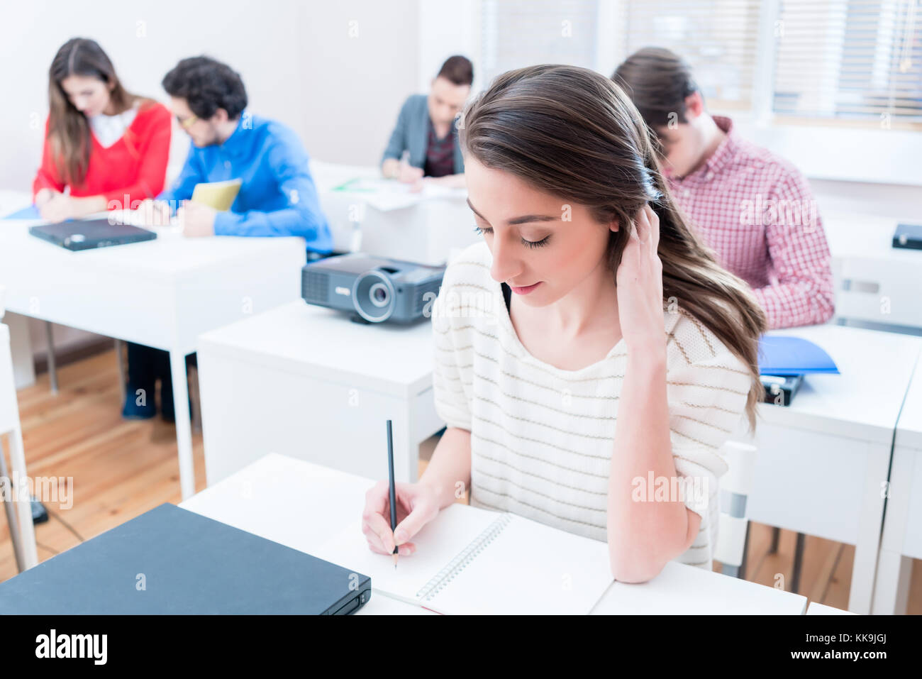 Student woman writing test in seminar room of university or having exam ...