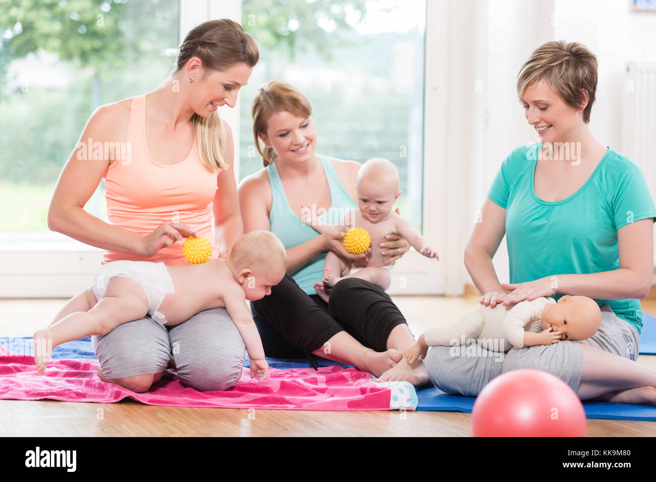 Young women practicing massage for their babies in mother-child class ...