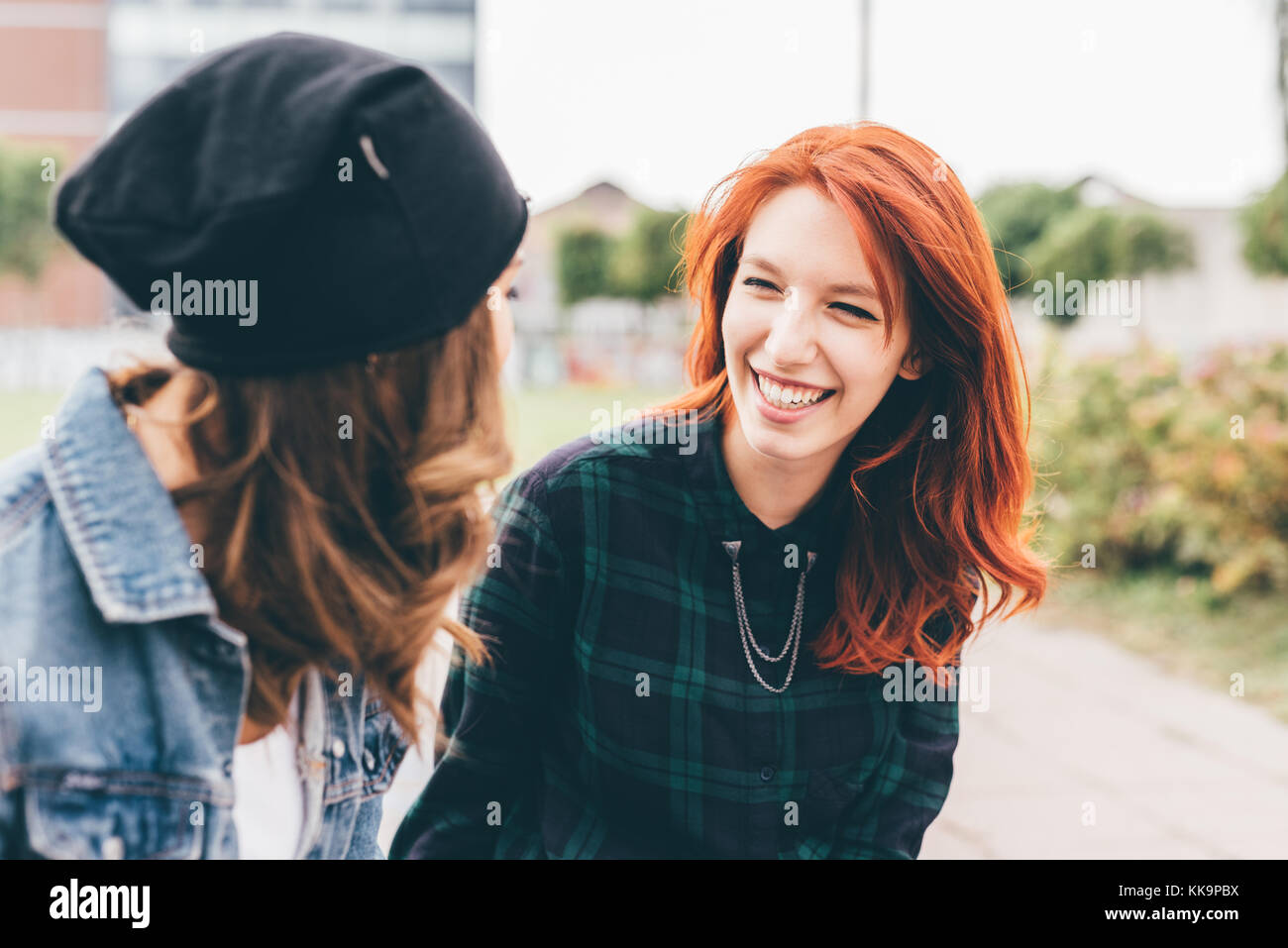 two young women outdoors having fun talking - interaction, communication, getting away from it ...