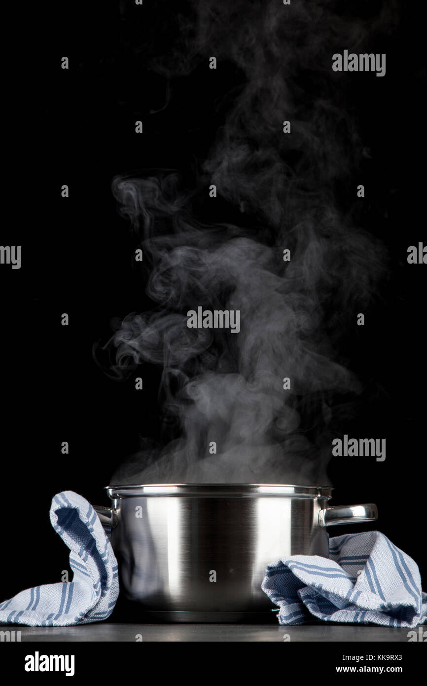 Steaming pot isolated on black background Stock Photo - Alamy