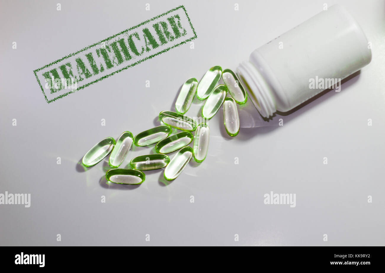 green pills and bottle isolated top view with healthcare text rubber ...