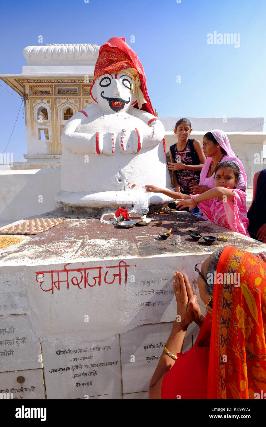 Female, Indian, Devotees making offerings to a statue of a god at a ...