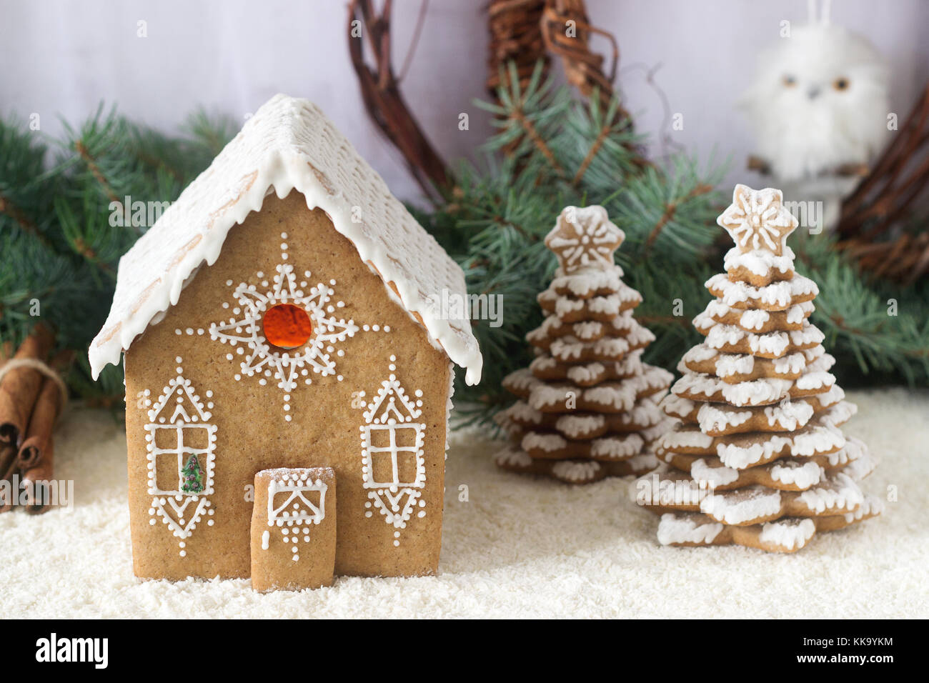Gingerbread house and gingerbread tree on a light background. Selective ...
