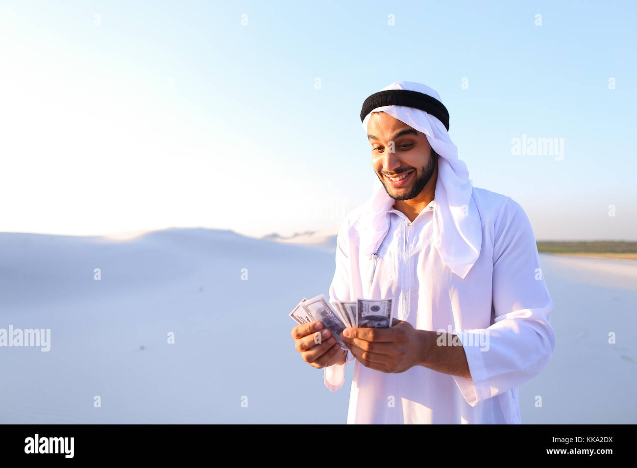 Successful Arab sheikh considers banknotes and happy, standing i Stock ...