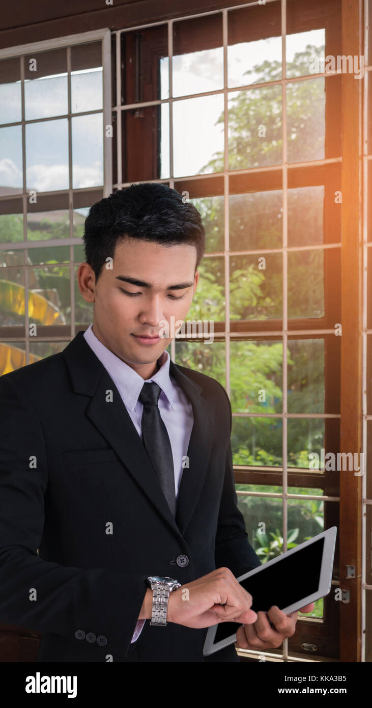 asian businessman holding tablet and looking at wrist watch Stock Photo ...