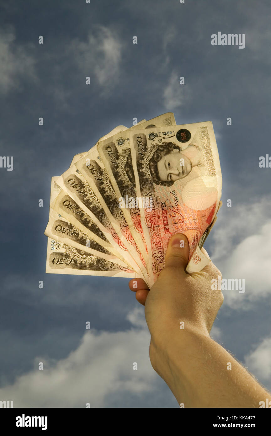 Hand holding stack of cash high up in the air Stock Photo - Alamy