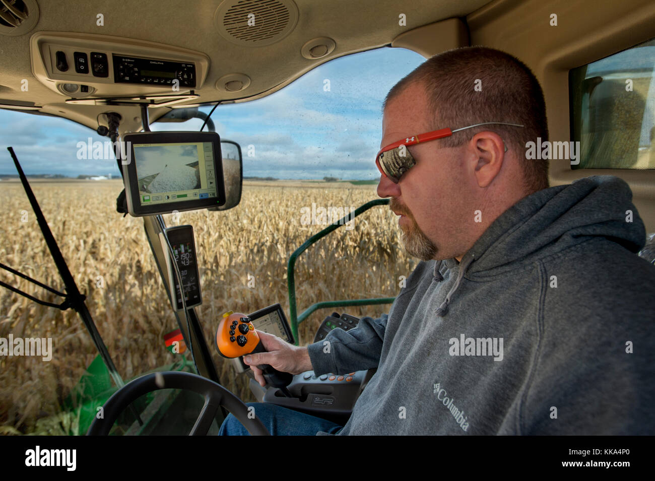 FARMER CLOSE UP PORTRAIT OPERATING COMBINE HARVESTER IN CORN FIELD IN ...